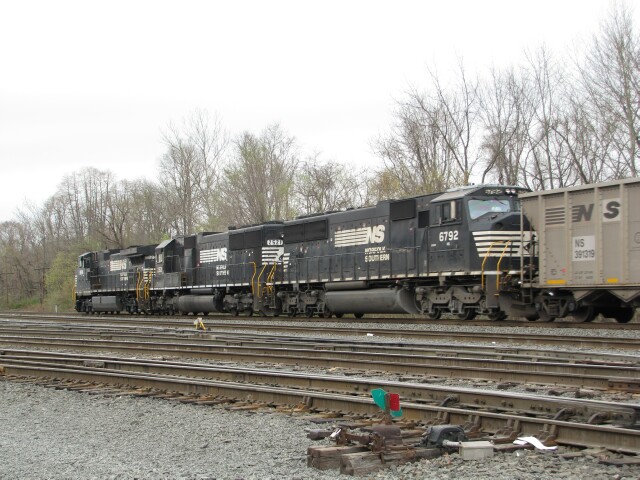 A trio of black hauls a string of varying shades of gray as NS 521 passes Abrams Yard.